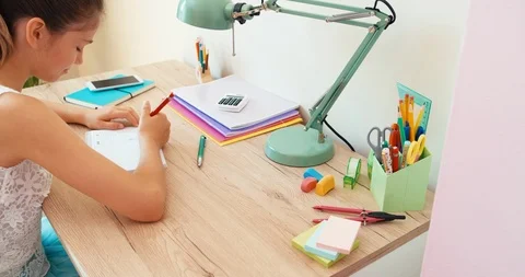 Teenager doing homework and smiling at c... | Stock Video | Pond5