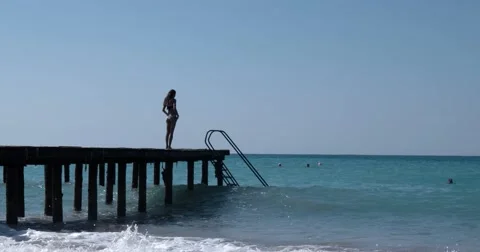 Teenager Girl Jumping From Pier Into the... | Stock Video | Pond5