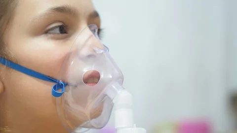 Teen's face inhaling through inhaler mas... | Stock Video | Pond5