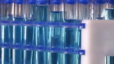 Test tubes with blue liquid rotating on ... | Stock Video | Pond5