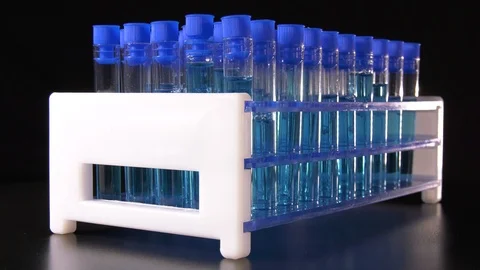 Test tubes with blue liquid rotating on ... | Stock Video | Pond5