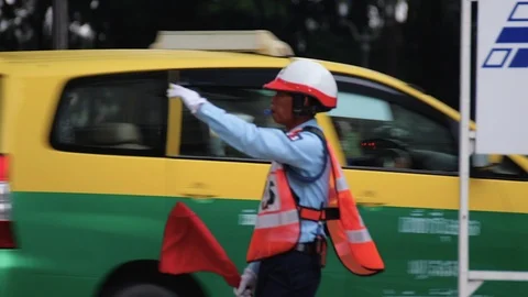Thai security guard directing traffic at... | Stock Video | Pond5