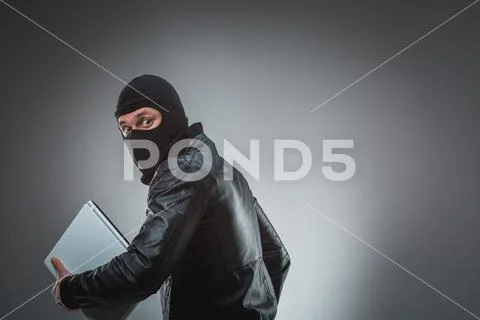 Thief stealing a laptop computer. Isolated on gray background ~ Premium ...