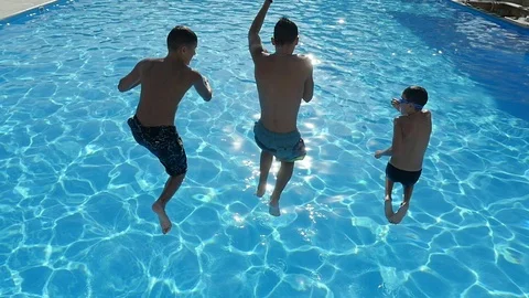 Three boys jumping feet first in a swimm... | Stock Video | Pond5