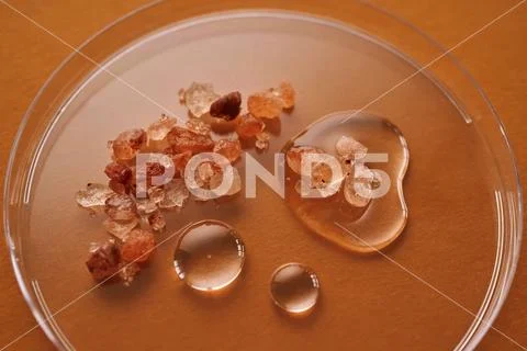 Three drops of liquid with pink salt on an orange background. ~ Premium ...