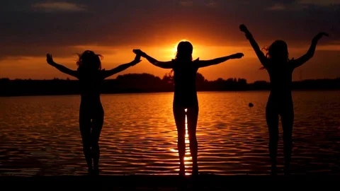 Three girls in bikinis dancing against t... | Stock Video | Pond5