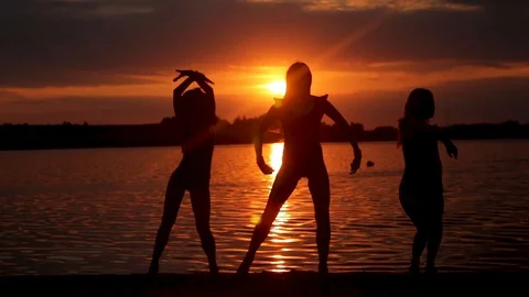 Three girls in bikinis dancing against t... | Stock Video | Pond5