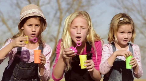 Three girls kids sisters blowing bubbles... | Stock Video | Pond5