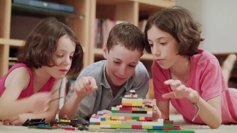 Three kids playing with lego bricks at h... | Stock Video | Pond5
