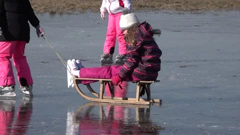 Three little girls on the ice, sledged t... | Stock Video | Pond5