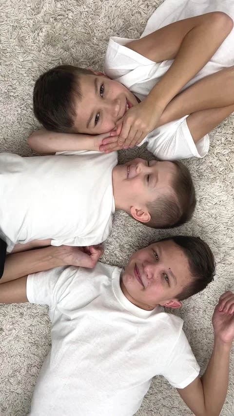 three siblings of different ages lie pla... | Stock Video | Pond5