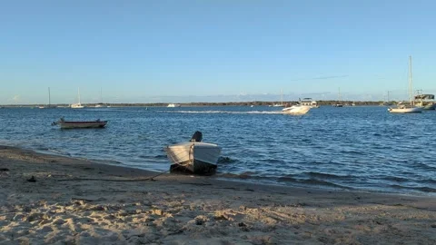 A tied up tinny on the beach bobs up and... | Stock Video | Pond5