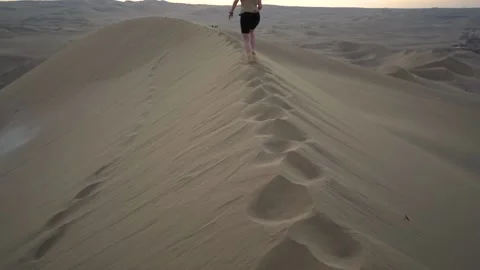 Tilt up showing girl walking on sand rid... | Stock Video | Pond5