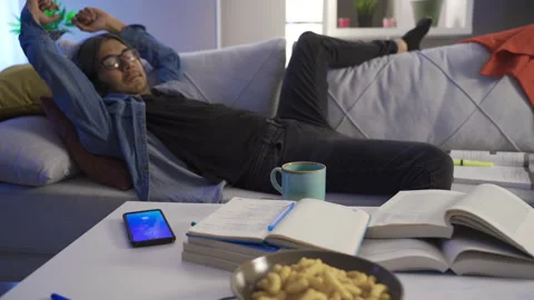 Tired lazy man lying on the sofa being w... | Stock Video | Pond5