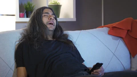 Tired man watching tv at the end of the ... | Stock Video | Pond5