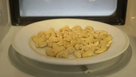 Toasting nuts using microwave. Roasted c... | Stock Video | Pond5