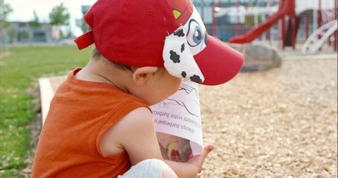 Toddler boy reading book on edge of park... | Stock Video | Pond5