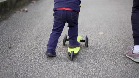 Toddler child riding three wheeled toy s... | Stock Video | Pond5