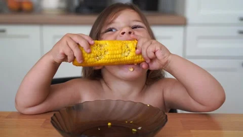 Toddler girl eating boiled corn maize. H... | Stock Video | Pond5