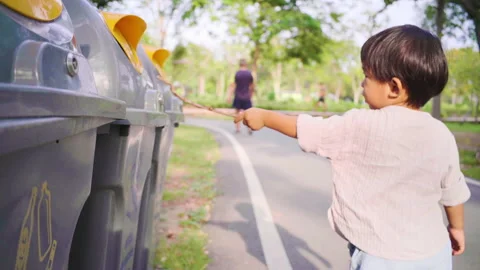 Toddler little boy throwing garbage to p... | Stock Video | Pond5