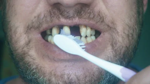 toothless man brushing his teeth | Stock Video | Pond5