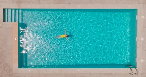 Top down view of a woman in yellow swims... | Stock Video | Pond5