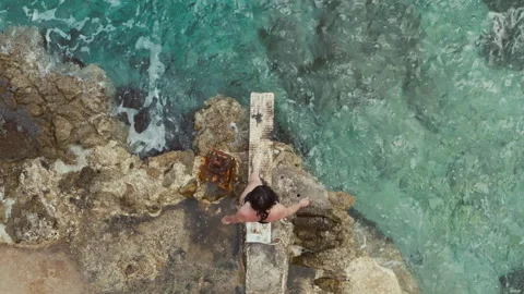 Top view aerial girl jumping into the oc... | Stock Video | Pond5