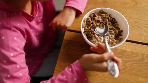 Top view little girl enjoy eating cereal... | Stock Video | Pond5