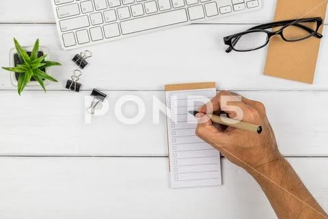 Top view of a man's hand writing on check list paper Stock Photo #94787640