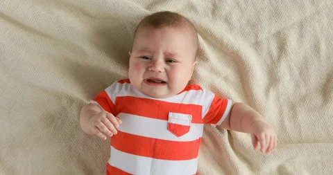 Top view portrait of crying baby, lying ... | Stock Video | Pond5
