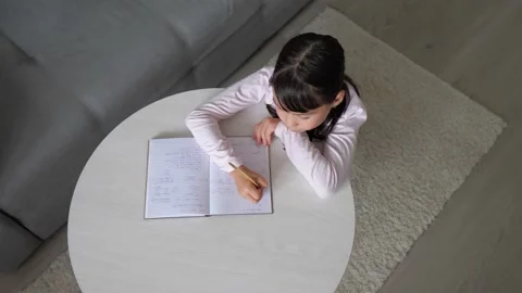Top view schoolkid sit at desk write in ... | Stock Video | Pond5