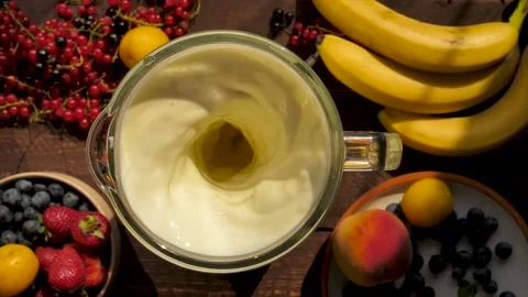 Top view slow mixing milkshake with yell... | Stock Video | Pond5