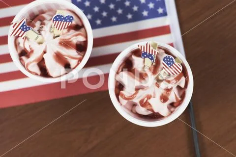 Top view of strawberry sundaes on top of the America flag on a wooden ...