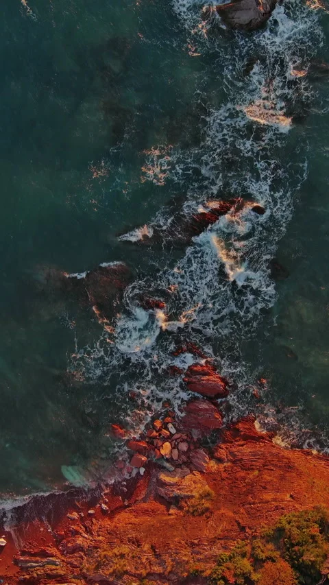 Top view of waves and red rocks in sea | Stock Video | Pond5