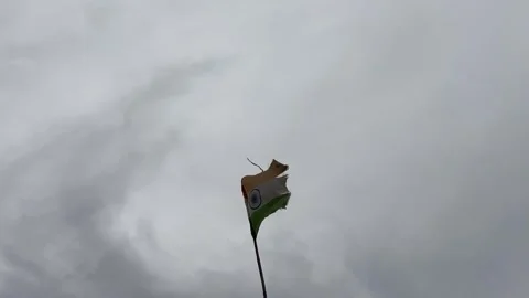 A torn Indian flag is fluttering in a cl... | Stock Video | Pond5