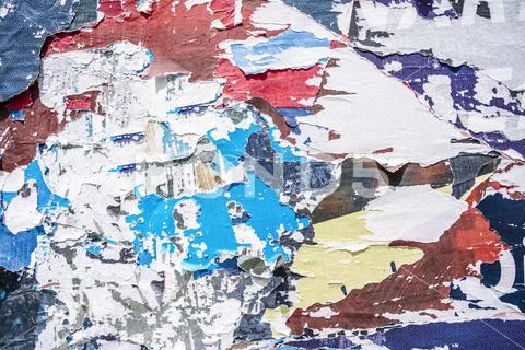 Torn paper collage background on an old poster on a street wall ...