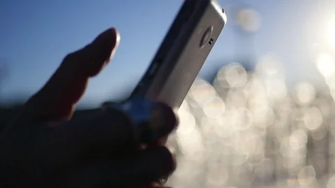 A touch phone in hands on a beautiful fl... | Stock Video | Pond5