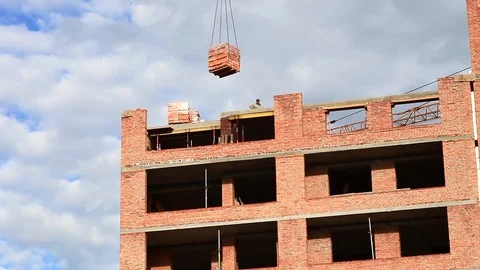 Tower crane lifts block of bricks to con... | Stock Video | Pond5