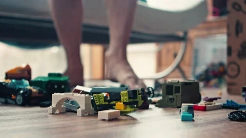 Toys scattered on floor and foot steppin... | Stock Video | Pond5