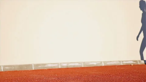 Track runner woman and her shadow on a w... | Stock Video | Pond5