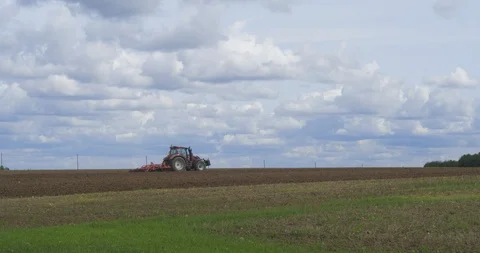 Tractor crossing a cultivated field with... | Stock Video | Pond5
