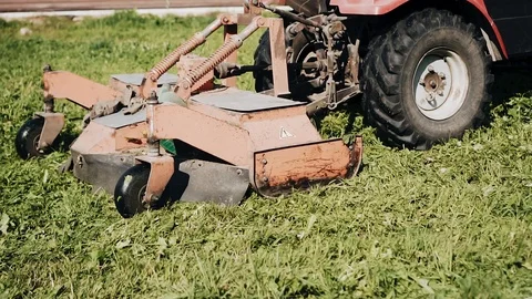 Tractor pulls a large lawn mower. Close ... | Stock Video | Pond5