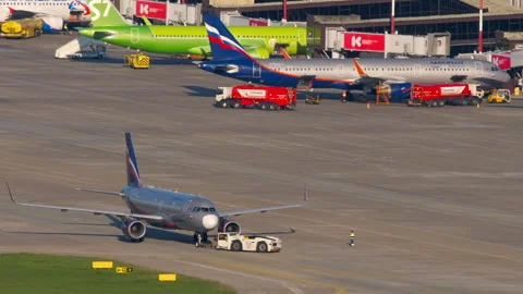 Tractor pulls plane to runway | Stock Video | Pond5
