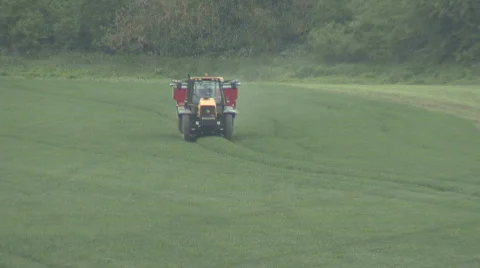 Tractor spraying fertiliser pellets send... | Stock Video | Pond5