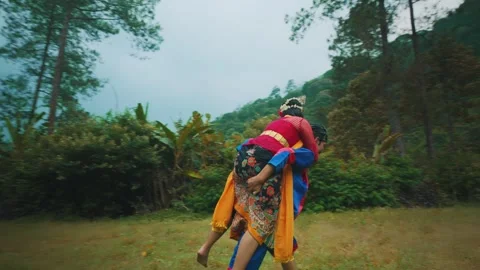 Traditional attire piggyback ride in nat... | Stock Video | Pond5