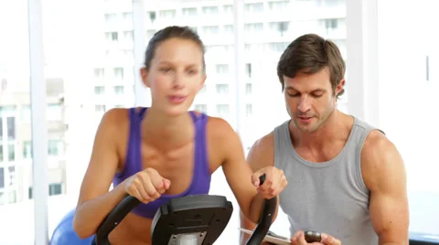 Trainer timing his client on exercise bi... | Stock Video | Pond5