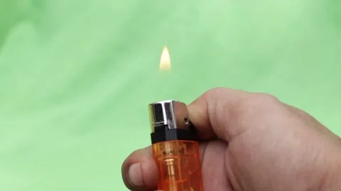 A transparent orange lighter lit by a pe... | Stock Video | Pond5