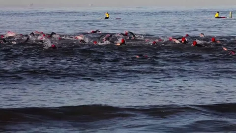 Triathlon swimmers swim in the ocean. | Stock Video | Pond5