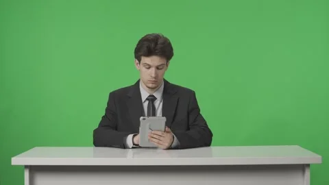 TV presenter sits at a table against the... | Stock Video | Pond5