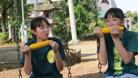 Twins eating corn | Stock Video | Pond5